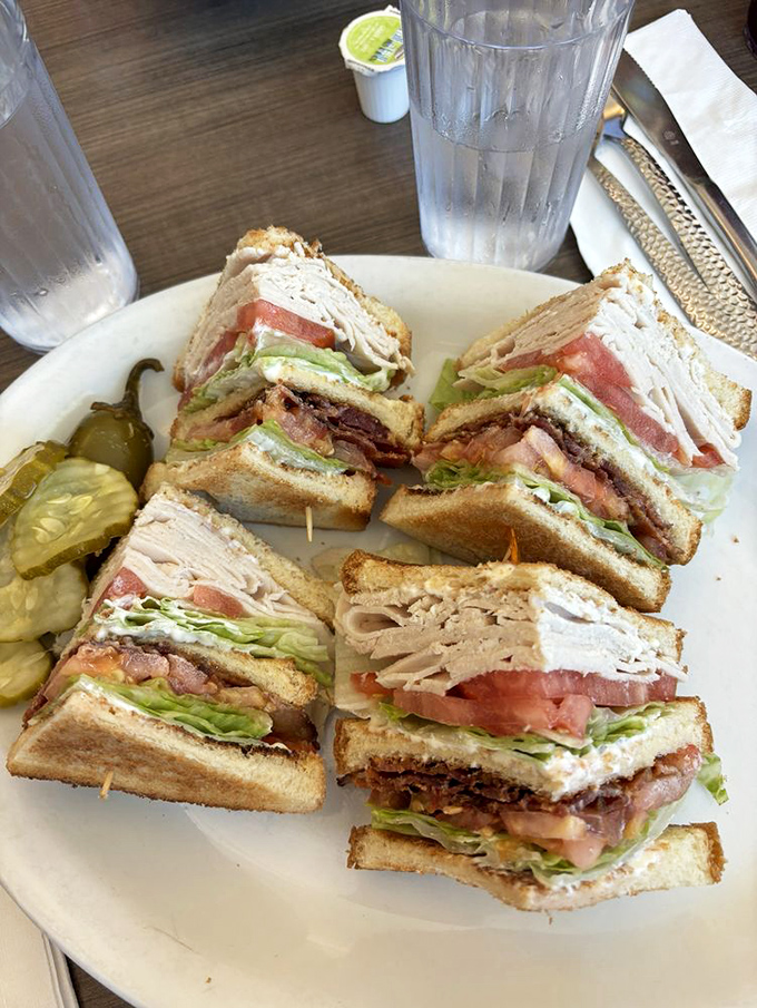 Behold the club sandwich in its natural habitat—a skyscraper of ingredients requiring engineering skills just to take the first bite.