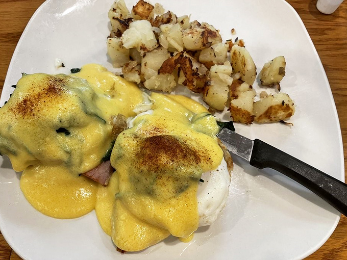 Behold the star attraction—eggs Benedict with hollandaise that cascades like a yellow waterfall of happiness. Worth every calorie and then some.