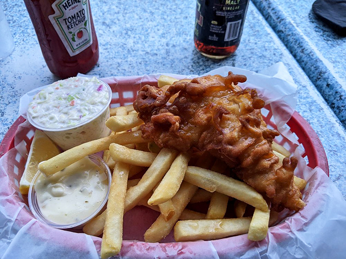 Golden-battered fish atop hand-cut fries with homemade coleslaw – proof that sometimes the classics need no reinvention, just proper execution.