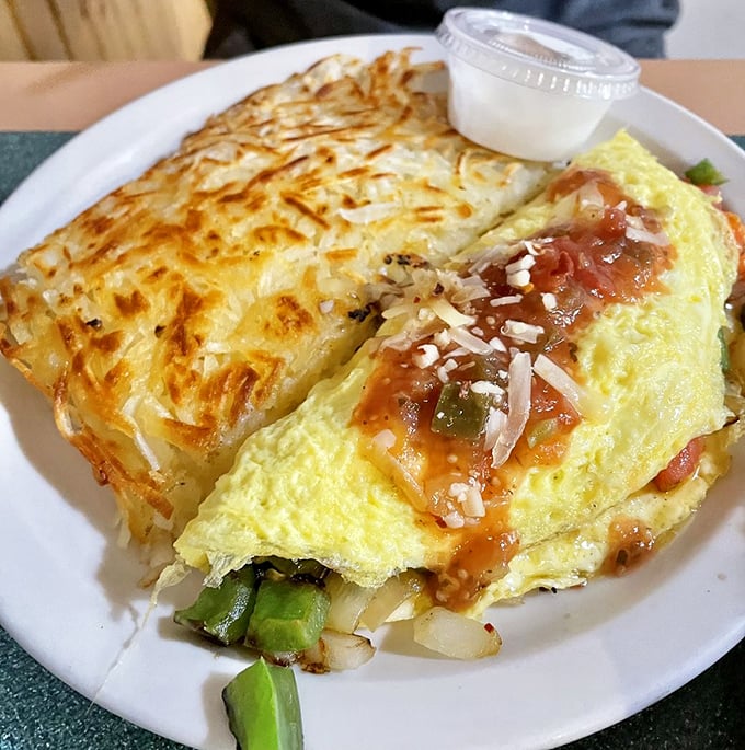 This isn't just an omelet—it's an architectural masterpiece of eggs, cheese, and salsa that makes chain restaurants weep with inadequacy.