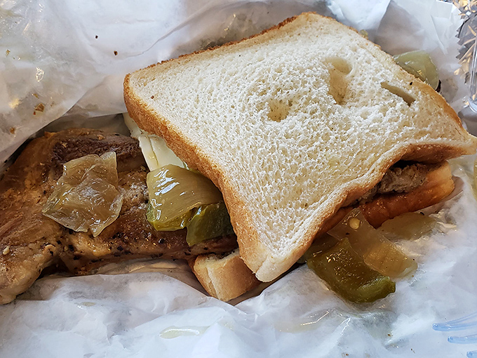 This isn't just a sandwich; it's a pork chop with green peppers and onions that decided to throw a party between two slices of bread.