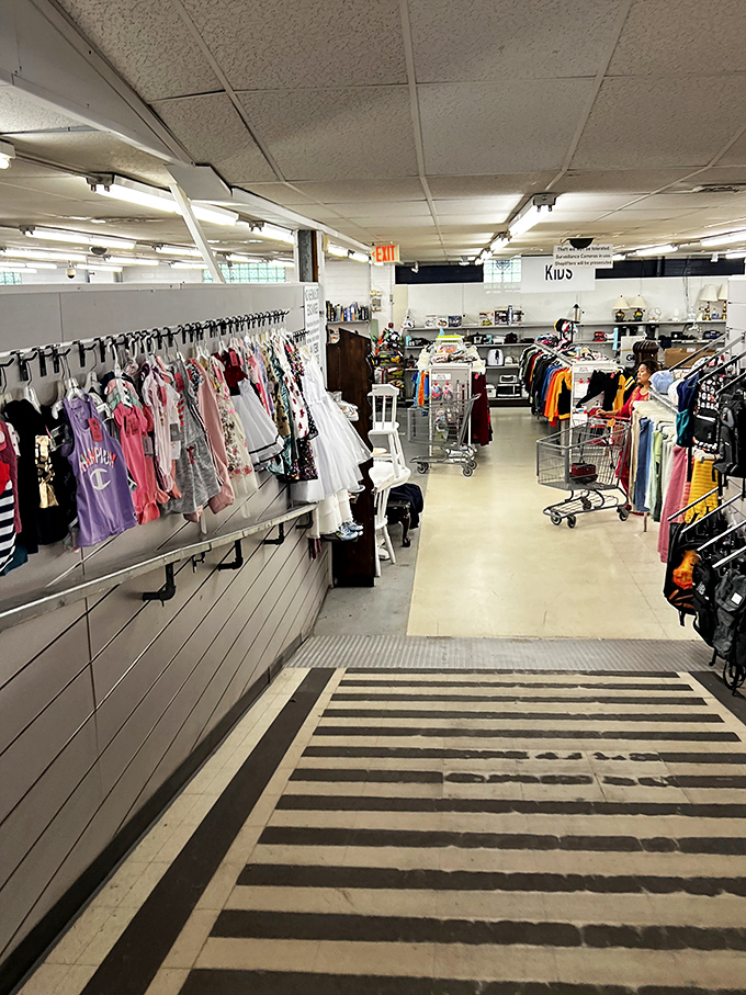 The kids' section ramp—where tiny formal dresses hang like prom memories waiting for their second chance at magic.