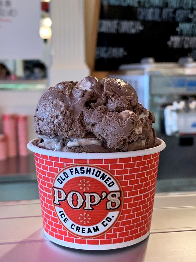 Chocolate so rich it should have its own tax bracket, sharing real estate with what appears to be rocky road—a decadent address indeed.