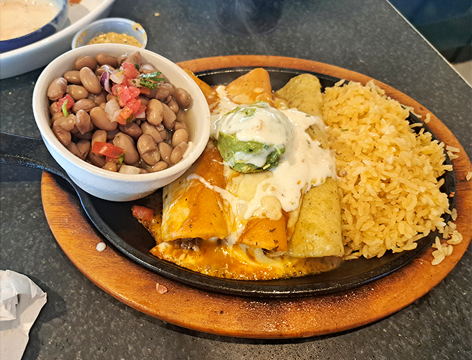 A sizzling enchilada plate that doesn't just satisfy hunger—it creates memories. That dollop of guacamole is the chef's kiss.