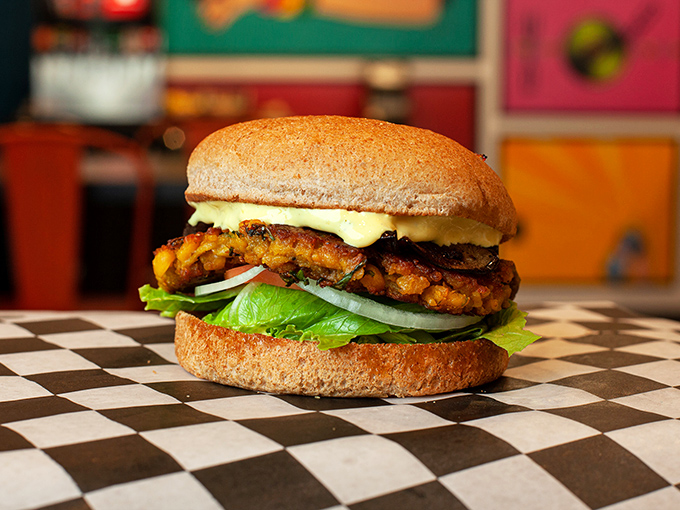 Architecture of deliciousness! This perfectly stacked veggie burger proves that plant-based can be indulgent without a hint of compromise.