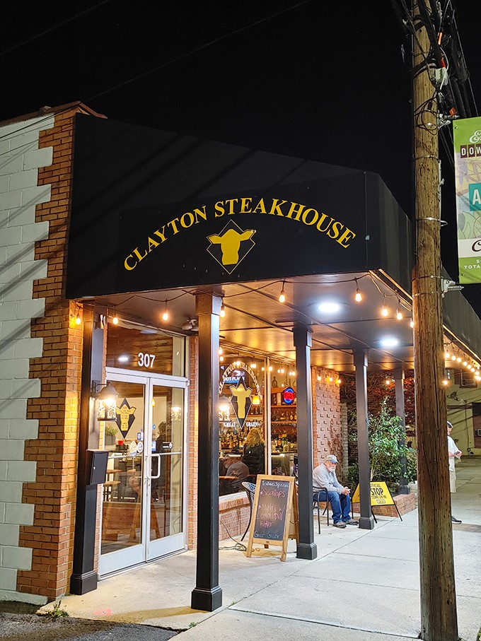 The warm glow of Clayton Steakhouse's evening lights beckons to hungry passersby like a lighthouse guiding ships to safe harbor—if ships were looking for perfect ribeyes.