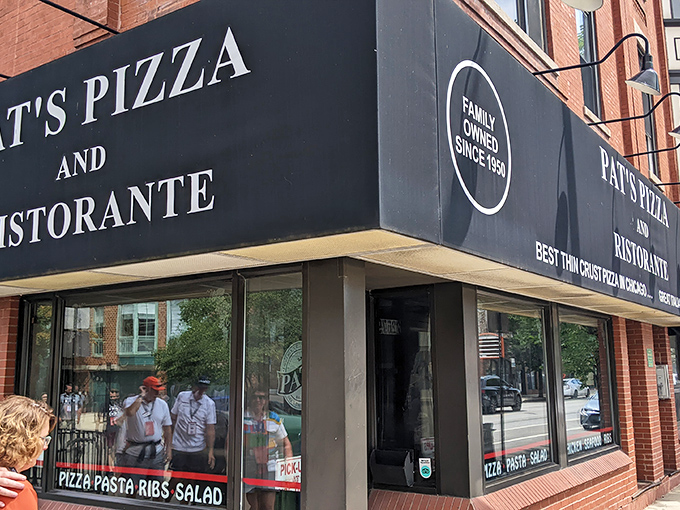 The simple black awning doesn't need flashy gimmicks—Pat's lets its legendary thin-crust pizza do all the talking.