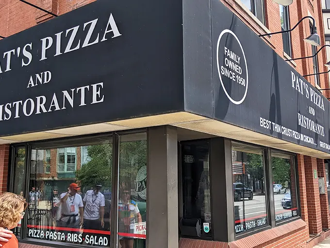 The simple black awning doesn't need flashy gimmicks—Pat's lets its legendary thin-crust pizza do all the talking.
