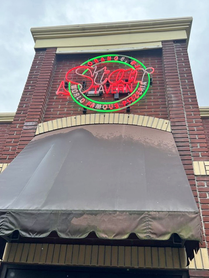 That neon sign isn't just advertising – it's a pizza lighthouse guiding hungry travelers to thin-crust nirvana in Orange.