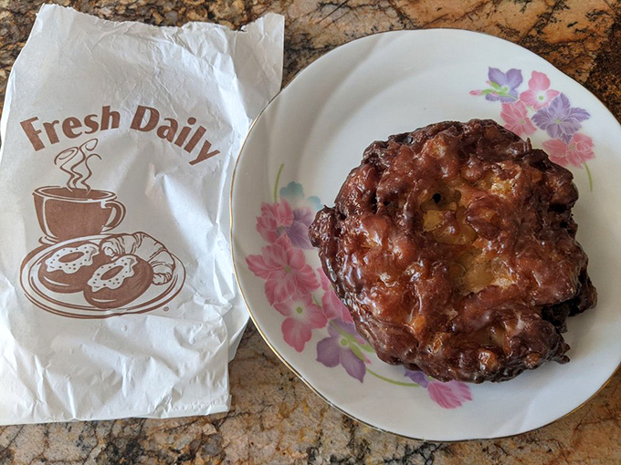 This apple fritter isn't just a pastry; it's a topographical marvel of crispy peaks and tender valleys, glistening with sweet apple glory.