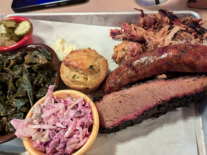 A barbecue platter that hits all the right notes – smoky meat with that perfect pink ring, purple slaw for tang, and sides that refuse to be mere afterthoughts.