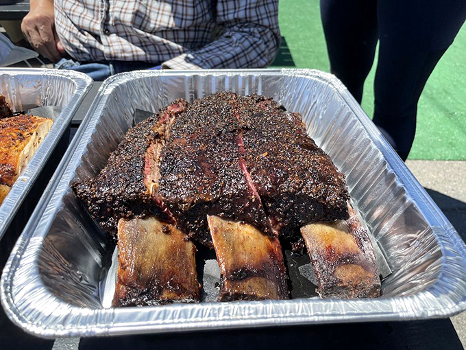 Beef ribs that look like they came from Fred Flintstone's butcher—gloriously crusted with pepper and smoke, ready to topple your prehistoric hunger.