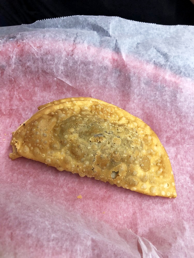 This golden-brown empanada isn't just fried dough with filling—it's a portable treasure chest of savory goodness waiting to be unlocked.