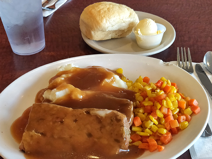 The holy trinity of diner perfection: perfectly seasoned meatloaf, gravy-drenched mashed potatoes, and vegetables that somehow make you forget they're healthy.
