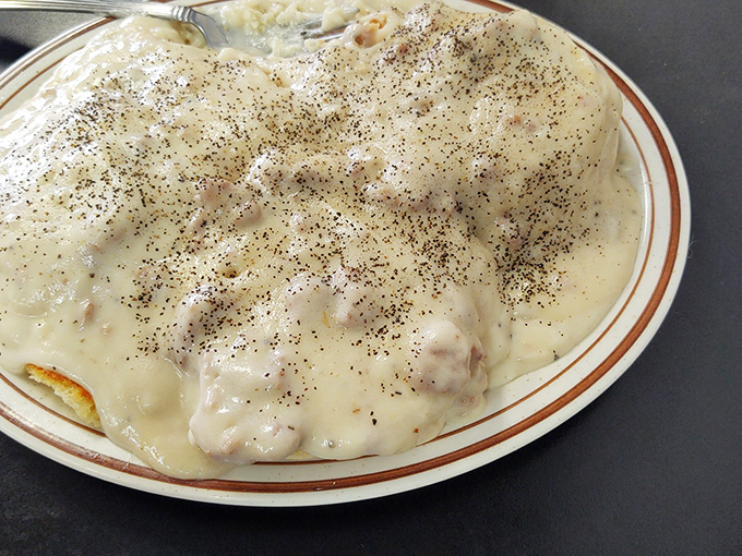 Biscuits drowning happily in creamy country gravy. Some mornings require more than coffee—they demand a proper blanket of peppery comfort.