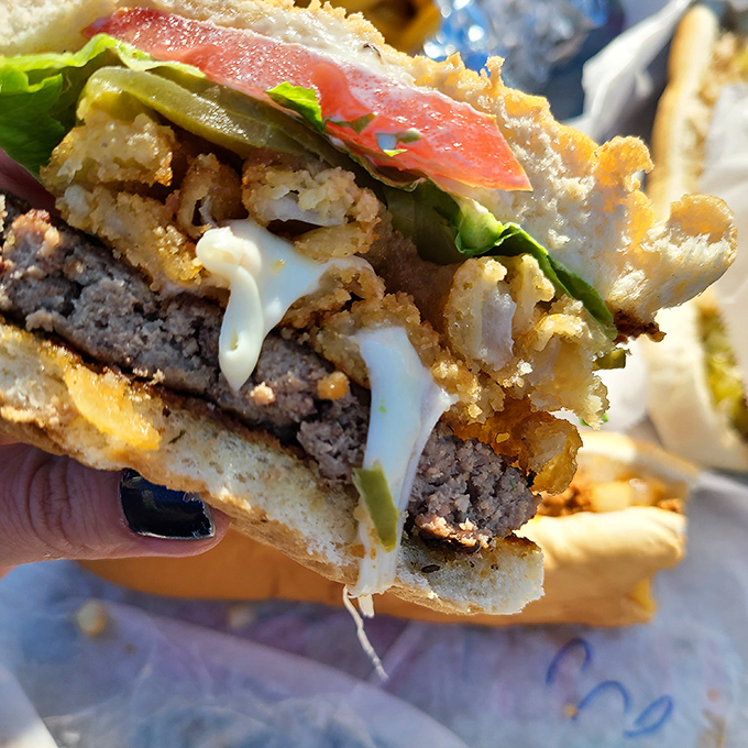 This isn't just a burger – it's an architectural marvel of beef, cheese, and toppings that requires both hands and complete dedication.