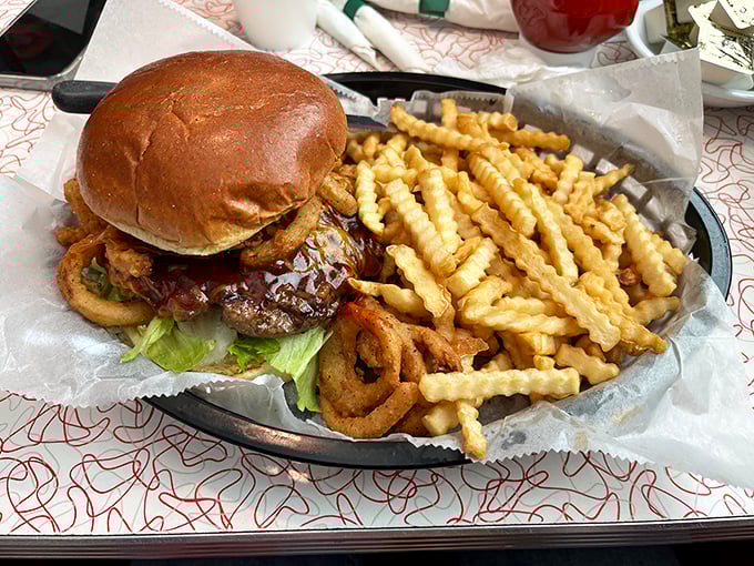 A burger that requires both hands and a strategy, accompanied by crinkle-cut fries that audibly crunch with each heavenly bite.