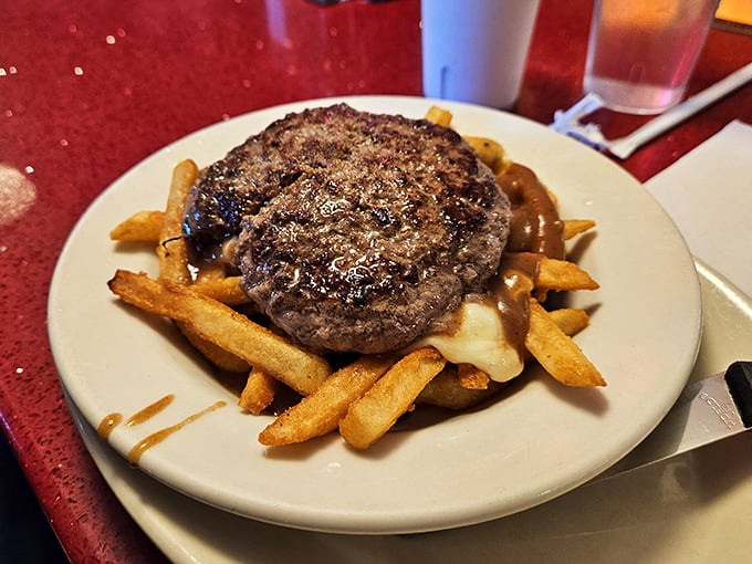 This burger patty lounging on a bed of gravy-soaked fries isn't just a meal—it's a declaration of delicious independence from diet culture.