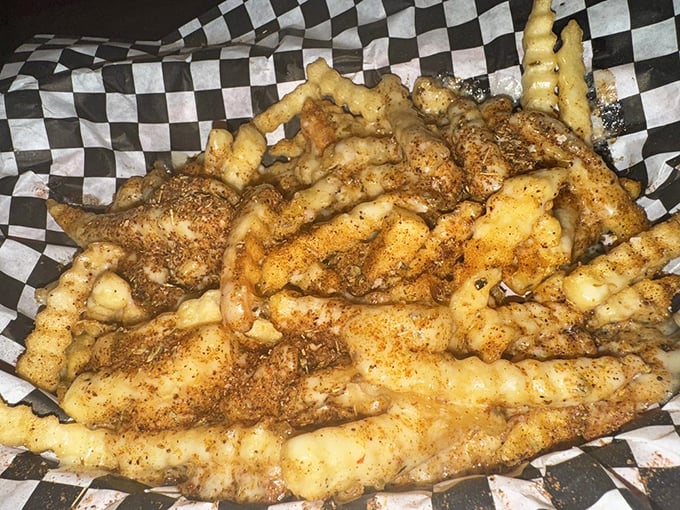 These aren't just fries—they're a crispy, seasoned intervention for your boring day. Served on checkered paper because some traditions just make sense.