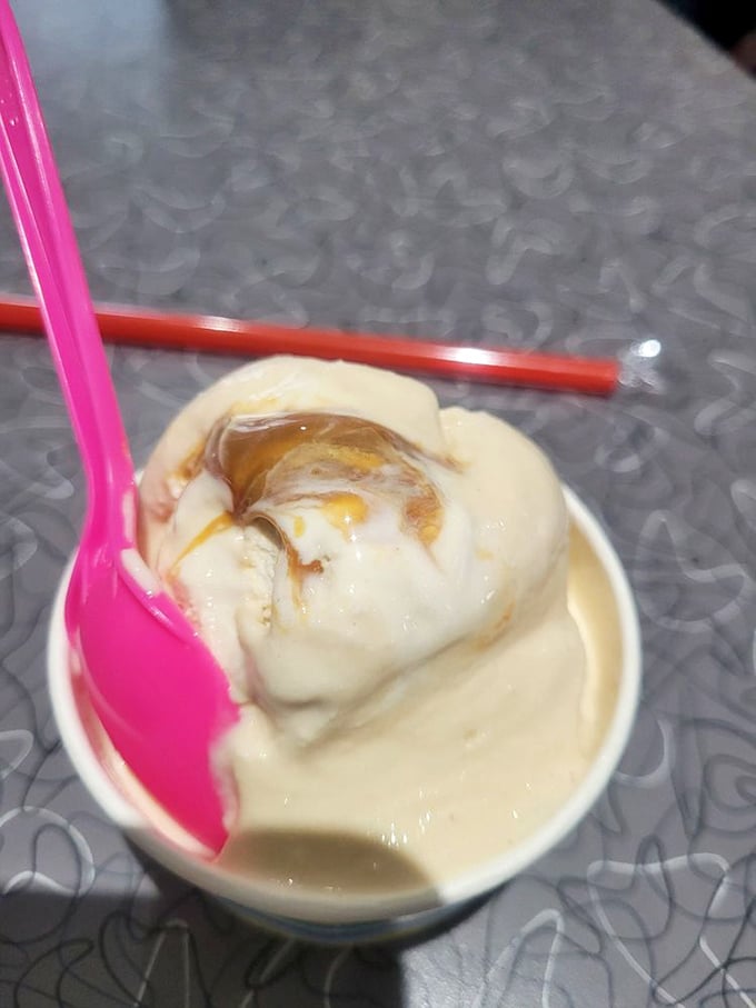 Caramel swirled into vanilla ice cream like a sweet meteor shower in a creamy galaxy. That pink spoon is your spacecraft for exploration.