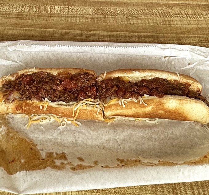 Behold the chili dog in all its messy glory – a reminder that the best foods require both napkins and a complete abandonment of dignity.