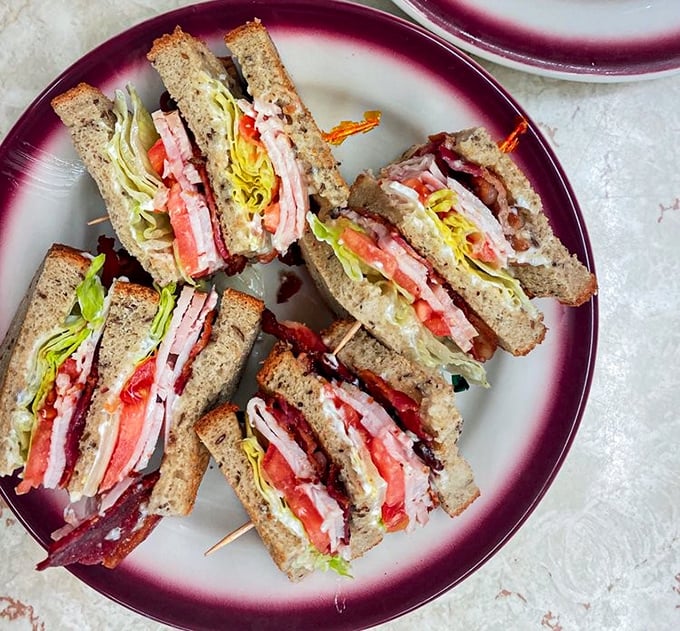 The club sandwich—architectural marvel of the diner world, where each precisely cut triangle reveals layers of deliciousness that put modern food stacks to shame.