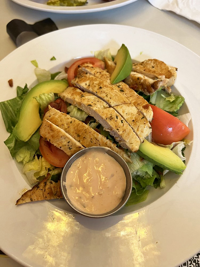A salad that doesn't apologize for being healthy—grilled chicken, avocado, and fresh veggies with dressing that means business.