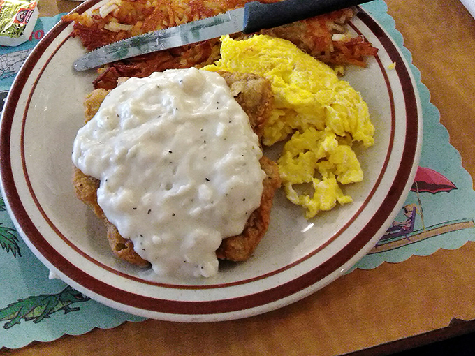 Country fried steak swimming in creamy white gravy – the breakfast equivalent of a warm hug from your favorite aunt who never learned the meaning of "portion control."