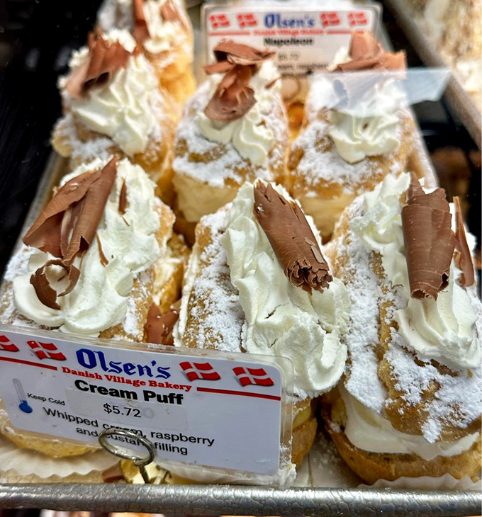 The legendary cream puffs—architectural marvels of pastry engineering filled with clouds of whipped cream and topped with chocolate curls. Dreams do come true.