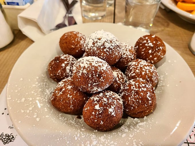 Donut holes dusted with powdered sugar – little bites of joy that arrive before you've even ordered. Resistance is both futile and foolish. 