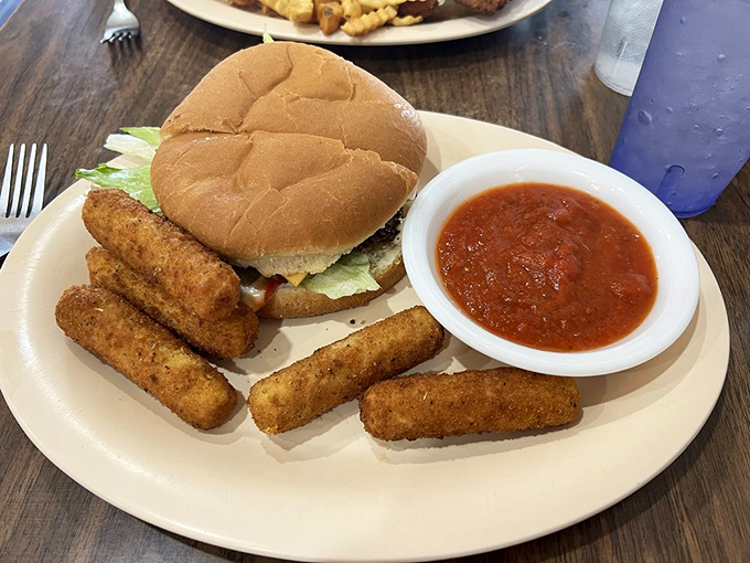 This isn't just a cheeseburger; it's the reason drive-thrus will never replace proper diners – melty cheese, fresh veggies, and fries worth stealing from your spouse's plate.