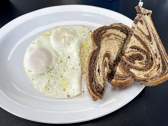 Two sunny-side up eggs with marble rye toast—proof that sometimes the simplest breakfasts are life's greatest luxuries.