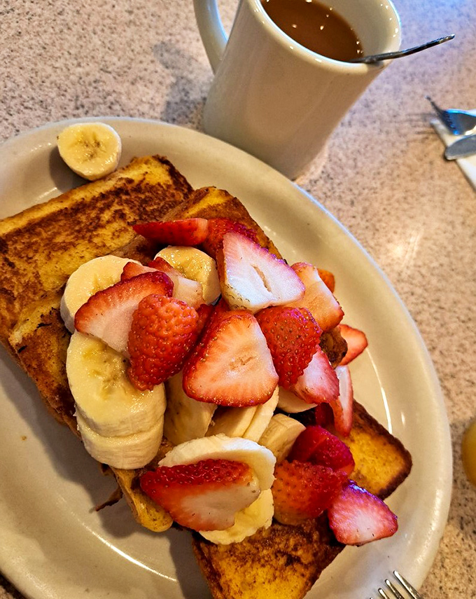 French toast transformed into a fruit-laden island of breakfast bliss. Those strawberries and bananas aren't just toppings—they're making a statement about starting your day right.
