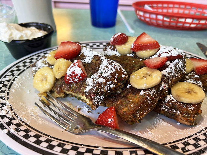 French toast that's having a party with fresh fruit. The powdered sugar isn't falling—it's making a grand entrance.