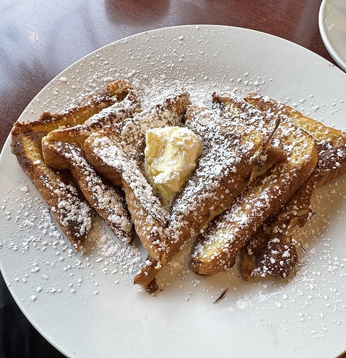 French toast that's dressed for success—crisp edges, custardy centers, and enough powdered sugar to make your coffee jealous.