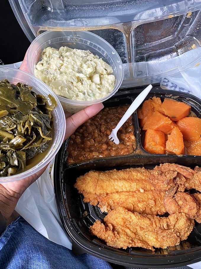 A takeout feast that makes your car smell better than any air freshener ever could. Collards, potato salad, and golden fried seafood—the holy trinity of Southern takeout.