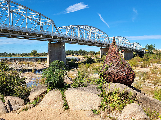 The Roy Inks Bridge frames nature's artwork beneath it, where river-smoothed stones create their own kind of Texas poetry.