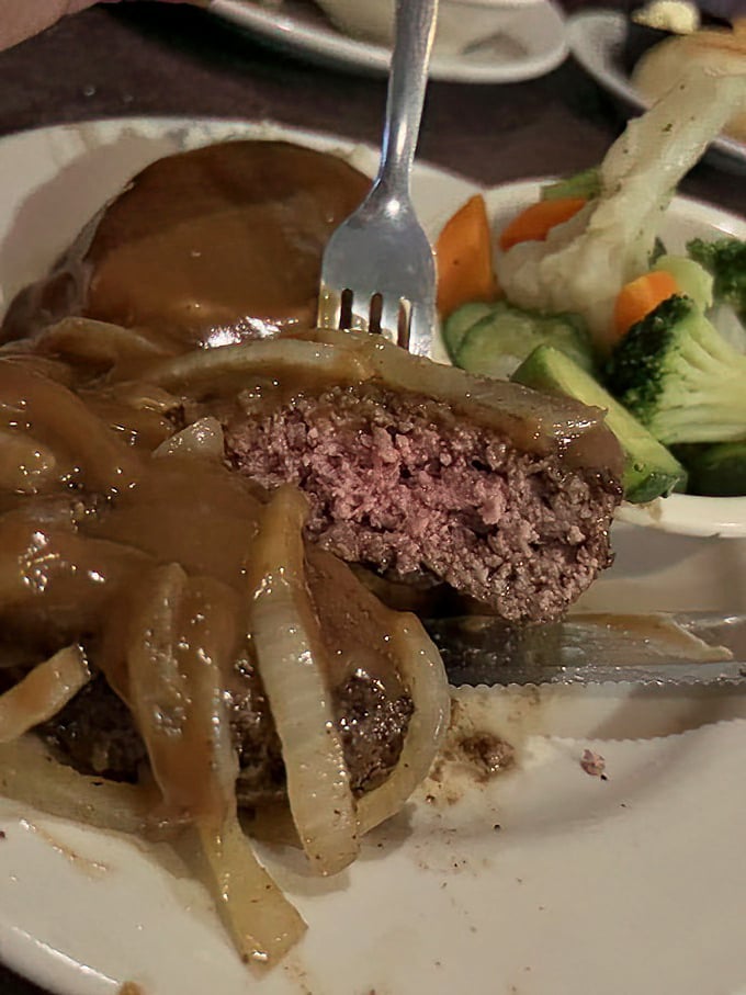 The hamburger steak hiding beneath those caramelized onions isn't playing games—it's serious comfort food with a side of nostalgia.