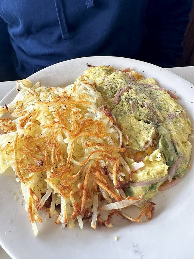 Golden hash browns meeting a fluffy omelet—the breakfast power couple that's been delivering morning joy longer than most marriages last.