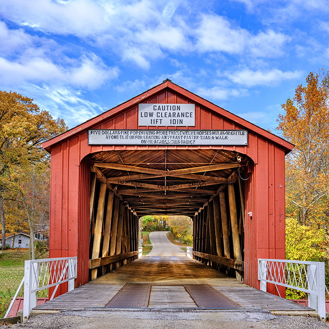 The Red Covered Bridge stands as a crimson sentinel guarding the past, inviting you to slow down and travel through time at 5 mph.