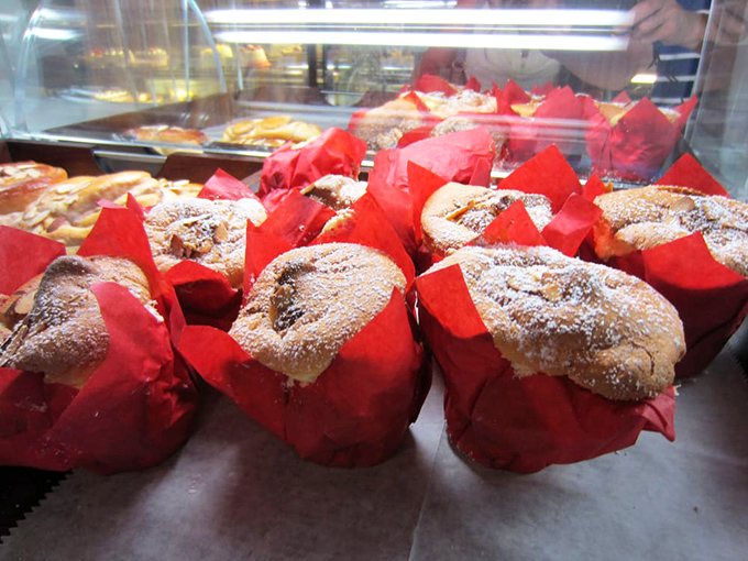 These red-wrapped muffins aren't just waiting to be eaten; they're practically performing in their own delicious Broadway show behind glass.