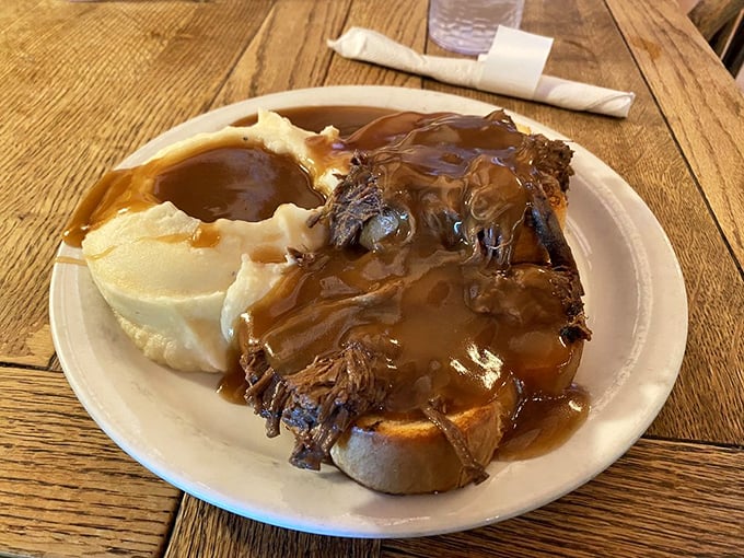 The hot beef sandwich – where tender pot roast meets gravy in such perfect harmony that musical directors should study it for inspiration.
