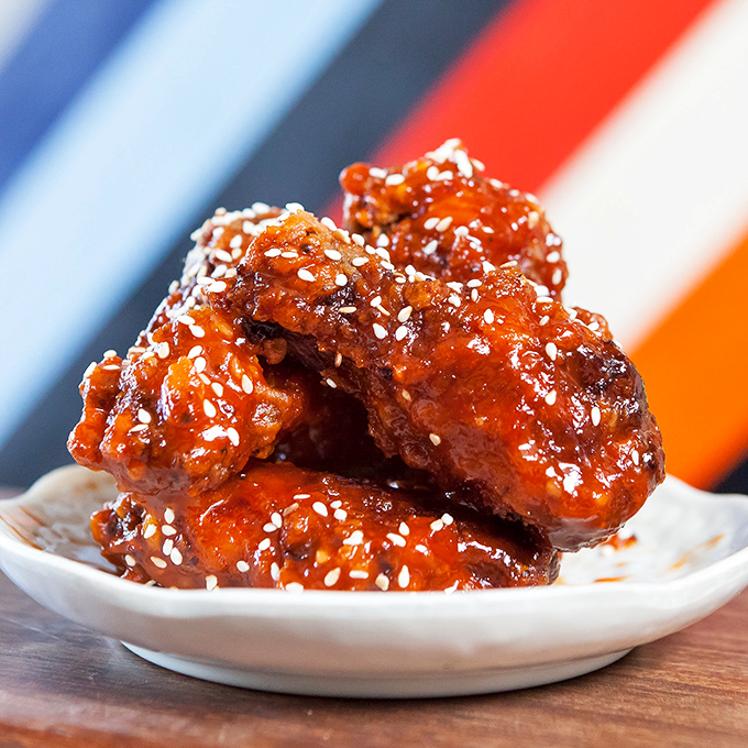 These Korean fried chicken bites aren't just glazed—they're jeweled. Each sesame-studded morsel glistens with a sauce that's equal parts sweet, spicy, and addictive.