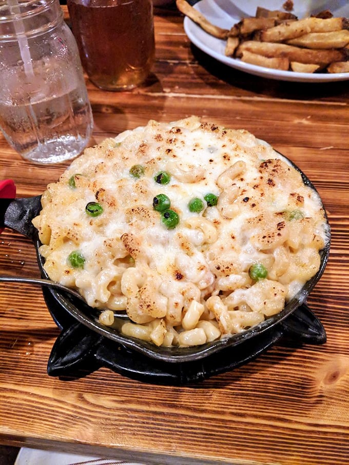 Mac and cheese that doesn't just comfort—it embraces you. Those crispy edges and green peas add textural contrast to creamy, cheesy perfection.