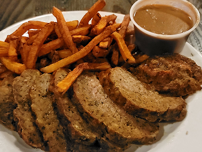 Sliced meatloaf with golden fries and gravy for dipping—proof that some food combinations are simply meant to be together forever.