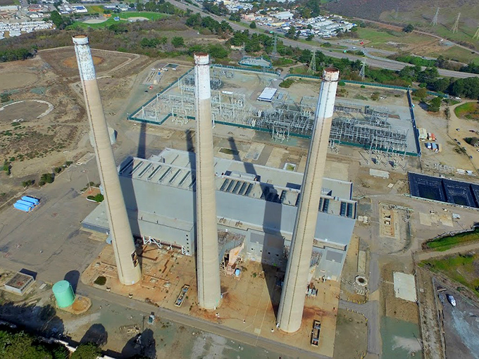 Even industrial structures take on an artistic quality against the coastal landscape, their three towers standing like modern monuments.