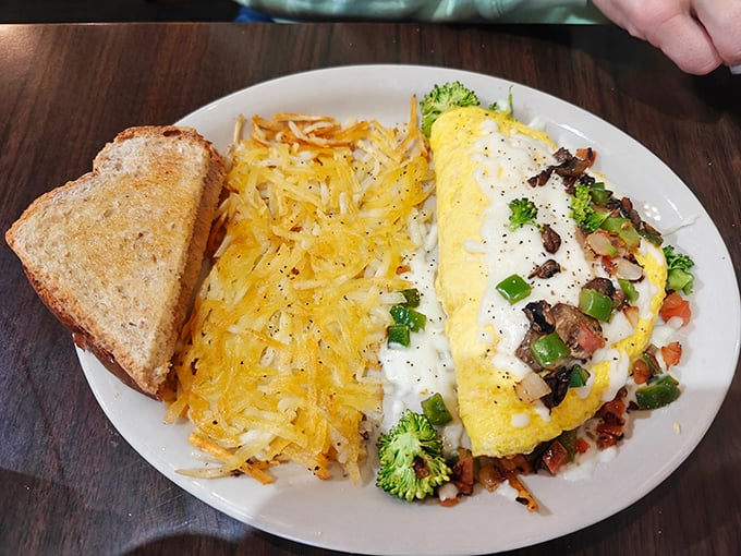 This isn't just an omelet—it's a vegetable treasure chest wrapped in fluffy egg. Those hashbrowns aren't sidekicks; they're co-stars of this breakfast production.