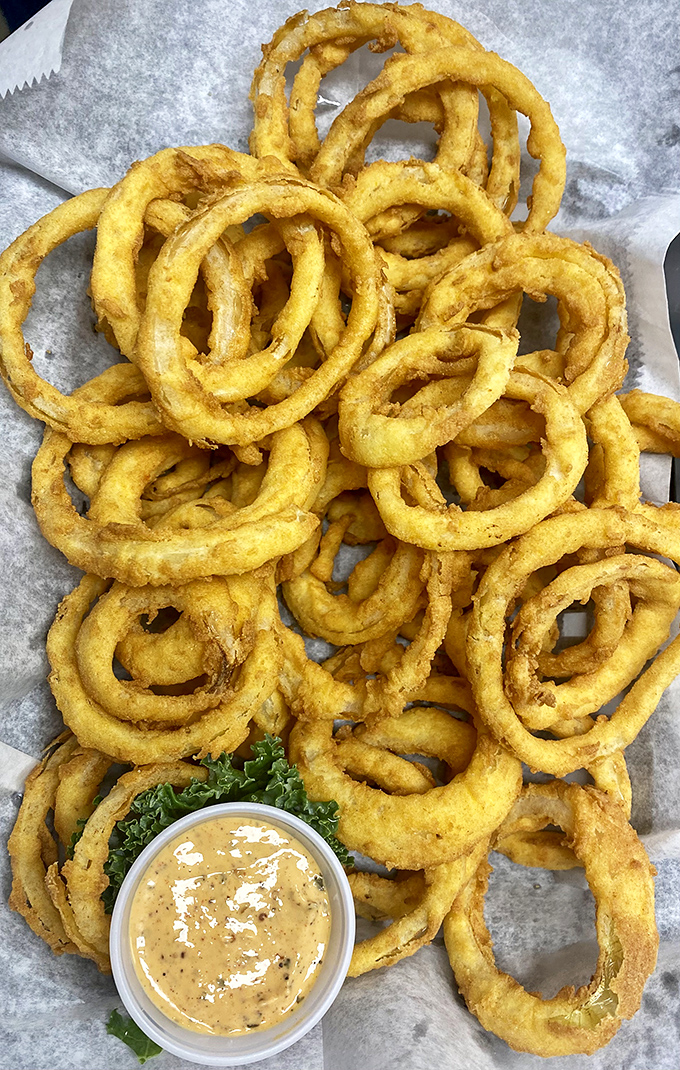 These onion rings aren't just fried—they're golden halos of crispy perfection that make you question why anyone would ever choose fries instead.