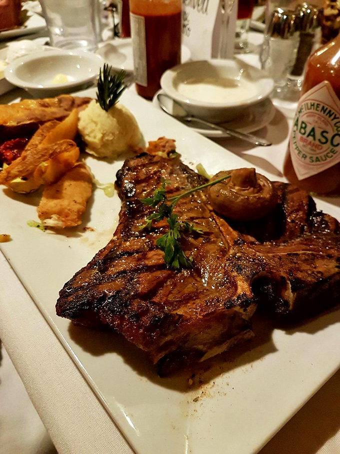The porterhouse arrives like a magnificent sculpture of beef, making neighboring diners pause mid-conversation to witness its glorious entrance to your table.