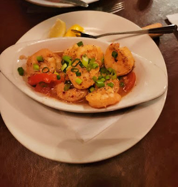 Plump shrimp swimming in a garlicky sauce with bright scallions—seafood that tastes like it just had a spa day in butter.